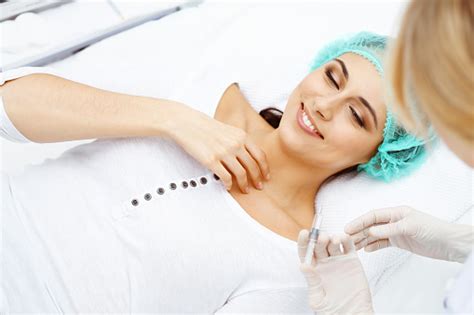 얼굴 입술에 주사를 만드는 전문 미용사 젊은 여자는 얼굴 윤곽 또는 확대를 위한 필러와 주사기를 가져옵니다 얼굴 노화 회춘 및 수분 공급 절차 18 19세에 대한 스톡 사진