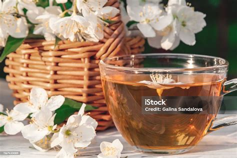 여름에 야외에서 흰색 나무 트레이에 향기로운 재스민 차와 자스민 또는 모의 오렌지와 컵이라고 어딘가에 필라델푸스의 꽃 바구니 0