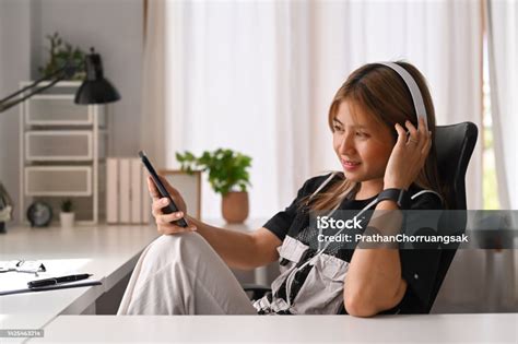 집에서 자유 시간을 보내고 좋아하는 노래를 즐기는 무선 헤드폰을 착용 한 행복한 젊은 여성 20 24세에 대한 스톡 사진 및 기타 이미지 Istock