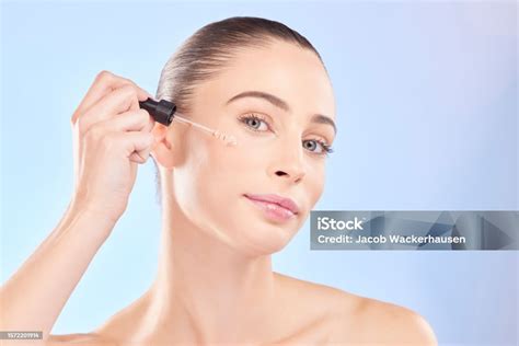 여자 초상화 얼굴 미적 스킨케어 피부과를 위한 오일 세럼 여성 모델 얼굴 화장품 및 히알루론산 액체 콜라겐 및 뷰티 글로우의 스포이드가 스튜디오에서 빛납니다 사람 얼굴에