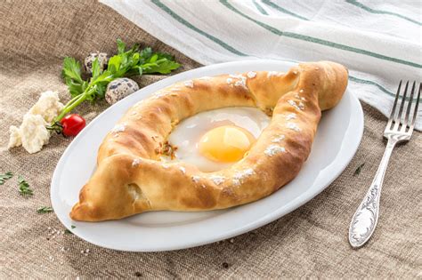 술구니 치즈가 채워진 빵과 달걀 노른자를 식탁보에 얹은 아자리리안 카차푸리 전통 그루지야 요리 0명에 대한 스톡 사진 및 기타 이미지 Istock