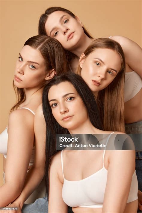 한 무리의 사람들의 초상화를 클로즈업하고 베이지색 스튜디오 배경 위에 함께 포즈를 취하는 흰색 상의를 입은 소녀들 뷰티 스킨 시술 18 19세에 대한 스톡 사진 및 기타
