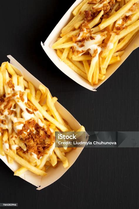 검은 배경의 종이 상자에 치즈 소스와 양파를 곁들인 감자 튀김 상단 보기 평면 누워 오버 헤드 위에서 클로즈업 0명에 대한 스톡 사진 및 기타 이미지 Istock