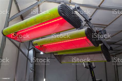 작업 환경에서 빨간 등불과 차체 수리 가게에서 흰색 오프로드 차량에 퍼티와 페인트를 적용 한 후 차체 부품의 적외선 건조