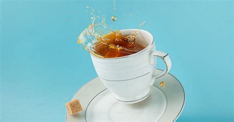 티백 레몬 설탕이 파란색 배경의 컵에 튀는 차 위에 밧줄에 매달려 있습니다 창조적 인 정물 사진 Unsplash의 컵 이미지