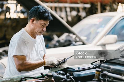 차고 아시아 전문 작업 자동 서비스 점검 엔진 태블릿 컴퓨터 튜닝 자동차 Ecu를 사용하는 정비사 2명에 대한 스톡 사진 및