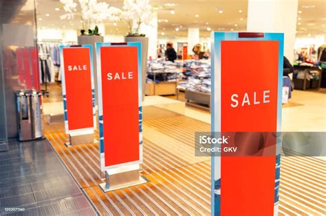 소매 쇼핑몰 입구에서 도둑 방지 게이트 센서에 빨간색 밝은 판매 배너 매장에서의 계절별 할인 혜택 상점에 대한 스톡 사진 및