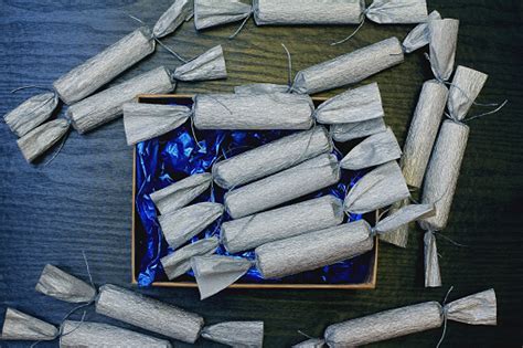 검은 나무 배경에 실버 래퍼에 사탕 파란색 포장지와 크래프트 상자 크리스마스 장식의 구성 상단 보기 플랫 레이 0명에 대한 스톡 사진 및 기타 이미지 Istock