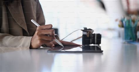 디지털 태블릿에서 작업하는 젊은 여성 사진작가 또는 디자이너의 손을 클로즈업합니다 사진 Unsplash의 앉아 이미지