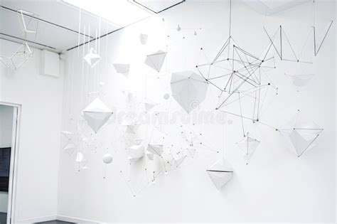 kinetic and interactive geometric art installation in modern minimalist room with white walls