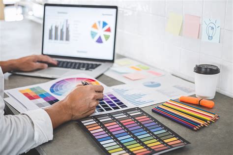 프로젝트 건축 드로잉 및 컬러 견본 작업 도구 및 장비그래픽 차트에 색칠 선택 작업 하는 젊은 창조적인 그래픽 디자이너 Cmyk