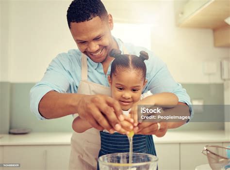 행복한 흑인 아버지와 딸이 부엌에서 굽고 장난스럽고 유대감을 느낍니다 돌보는 부모는 어린이 요리와 가정 기술을 가르치고 건강하고 맛있는 간식이나 식사를 함께 준비합니다 2