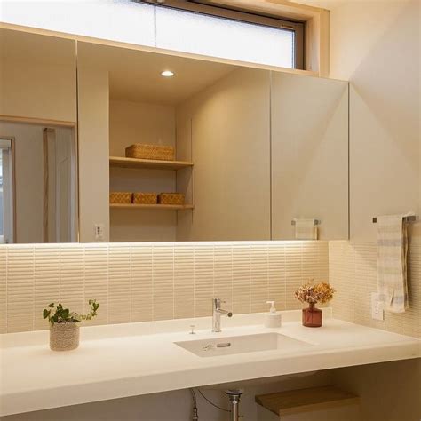 A Bathroom Sink Sitting Under A Large Mirror Next To A Shelf Filled