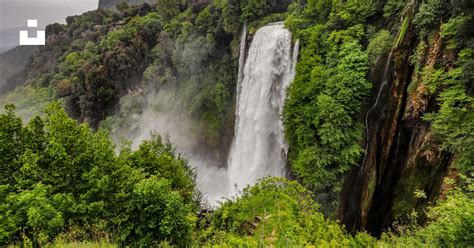 무성한 푸른 나무로 둘러싸인 큰 폭포 사진 Unsplash의 무료 자연 이미지