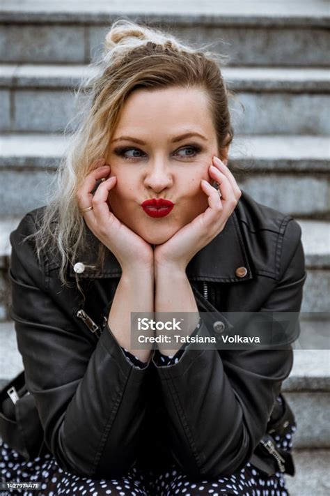 롤빵에 모인 긴 공정한 머리카락을 가진 젊은 아름다운 회색 눈동자 여성의 초상화 삐걱 거리는 입술에 빨간 립스틱을 착용 여자에