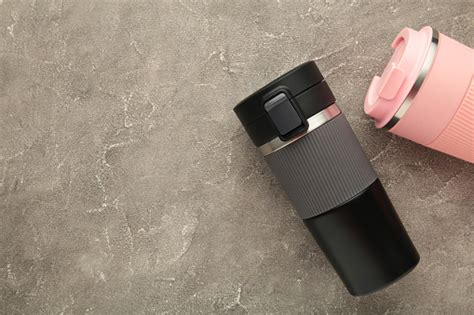 회색 배경에 차 또는 커피를 위한 두 개의 열 컵 또는 보온병 머그잔 그와 그녀를위한 검은 색과 분홍색 커플을위한 뜨거운 음료