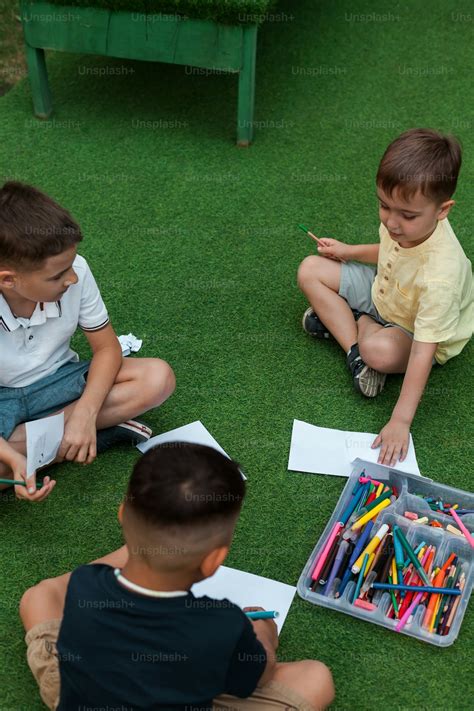 풀밭 위에 앉아 있는 한 무리의 어린 소년들 사진 Unsplash의 아이 이미지