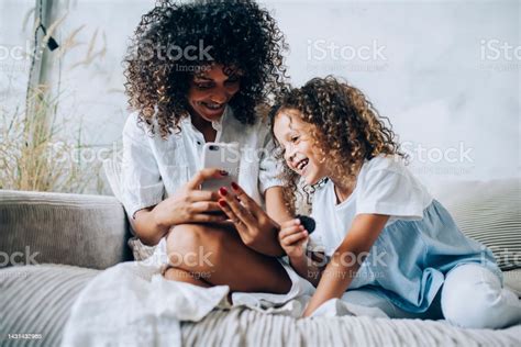 쾌활한 젊은 민족 여성과 집에서 스마트 폰을 사용하는 어린이 2명에 대한 스톡 사진 및 기타 이미지 2명 30 34세 6 7 살 Istock