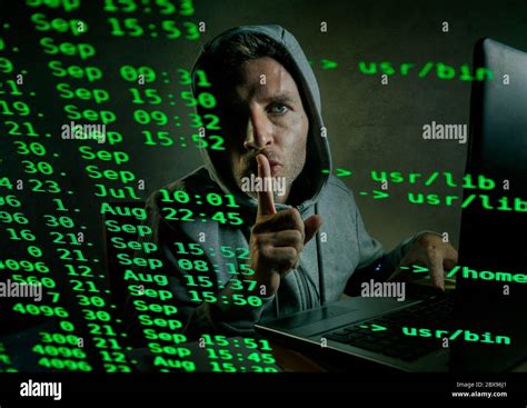 computer programmer man in hoodie hacking system entering code typing