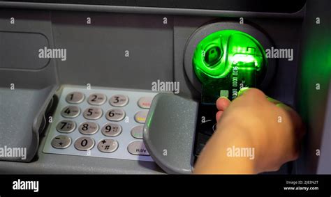 Hand Pushes Credit Card Into An ATM Enters Secret Code Withdraws Money Stock Photo Alamy