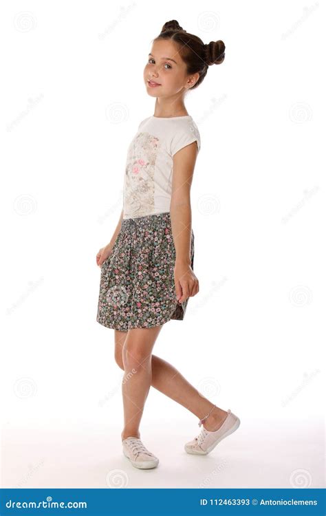 Красивая маленькая девочка брюнет 12 лет старый представлять в юбке с чуть чуть ногами Стоковое