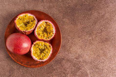 복사 공간이있는 갈색 배경에 전체와 컷 익은 육즙이 많은 열대 열정 과일이있는 둥근 접시의 위 보기 0명에 대한 스톡 사진 및 기타 이미지 Istock