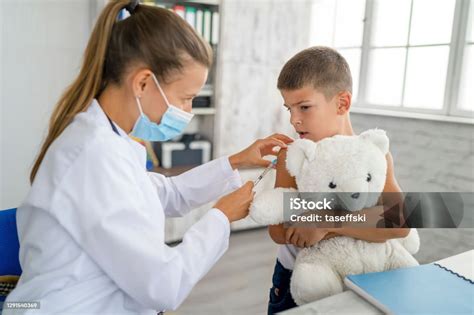의사의 사무실에서 예방 접종을받고 사랑스러운 어린 소년의 초상화 부상에 대한 스톡 사진 및 기타 이미지 부상 소아과 의사 코로나바이러스 Istock