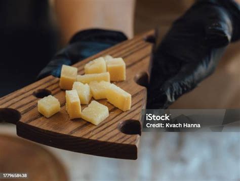 치즈 제조업자는 치즈 조각으로 그를 대접합니다 요리사의 손과 칼로 나무 판에 치즈 조각 치즈 자르기 치즈 썰기 클로즈업 갈색에 대한 스톡 사진 및 기타 이미지 Istock
