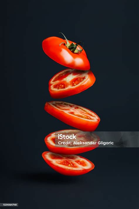잘 익은 빨간색 토마토는 수축 검은 배경에 고립 된 비행과 부양 조각으로 잘라 신선한 여름 샐러드 성분 원시 채식 주의 건강한 다이어트 성분 창조적 인 음식 개념 토마토