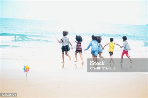 바다 물로 달리는 줄에서 손을 잡고 있는 여섯 명의 소년과 소녀 그룹 모래 여름 해변에서 즐거운 시간을 보내는 귀여운 아이들 열대 바다에서 노는 행복한 어린 시절 친구