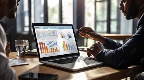 Premium Ai Image Two Analyst Works On A Laptop Showing Data Business