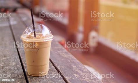 나무 테이블에 테이크 아웃 컵 라 떼 커피 얼음 나무 테이블에 짚으로 플라스틱 컵에 테이크 아웃 아이스 라 떼 나무 테이블에 아이스 라 떼와 카페가 게 배경 0명에 대한