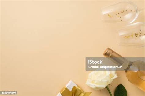 발렌타인 데이 장식 화이트 로즈 두 와인 잔의 최고 보기 사진 황금 스팽글 선물 상자와 골드 활과 카피 스페이스와 고립 된 베이지 색 배경에 화이트 와인 병 0명에 대한