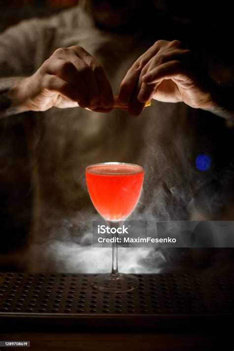 레몬 껍질을 들고 연기가 자욱한 바에서 칵테일과 함께 유리에 뿌려바텐더 바텐더에 대한 스톡 사진 및 기타 이미지 바텐더