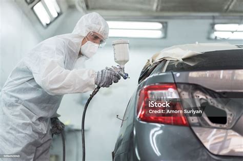 자동차 페인트 서비스 고품질 자동차 차체 공장 개념 자동차 페인트 정비소에서 자동차 차체에 스프레이 건 페인팅을 하는 남성 자동차 정비사 자동차 화가가 챔버에 차를 그리는