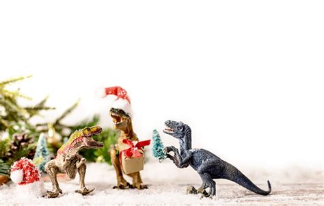 겨울 방학에 메리 크리스마스 흰색 배경에 가짜 눈이 있는 산타 모자를 쓰고 있는 공룡 장난감 12월에 대한 스톡 사진 및 기타 이미지 Istock