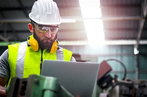 헬멧과 안전한 안경을 쓰고 공장 공장에서 기계를 작동하기 위한 노트북 컴퓨터를 들고 산업 컨셉의 기계와 함께 일하는 산업 엔지니어 작업자 경영자에 대한 스톡 사진 및 기타