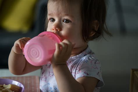 집에서 테이블에 앉아있는 한 소녀 작은 백인 아이가 아침 식사 또는 점심 식사 음료 요구르트를 혼자 먹는 하루 동안 실제 사람들은 개발 개념 복사 공간을 자랍니다 12 17