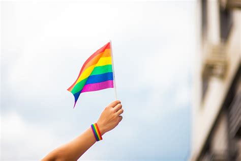 하늘에 무지개 깃발게이 프라이드 팔찌를 입고 여성손 성소수자 사람들 동성 관계 및 동성애 개념 자랑스러움에 대한 스톡 사진 및 기타 이미지 Istock