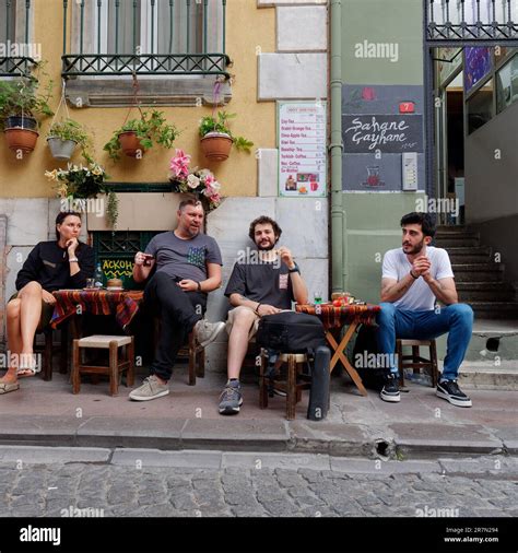 Friends Enjoying A Turkish Tea On Informal Table And Chairs On A