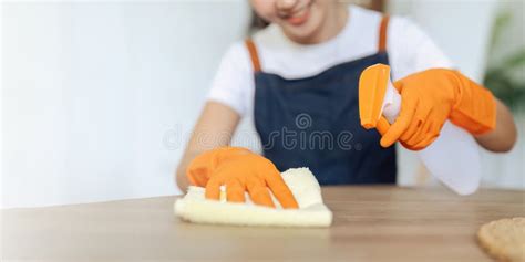 Young Woman Cleaning Using Spray And Wiping The Table With Microfiber