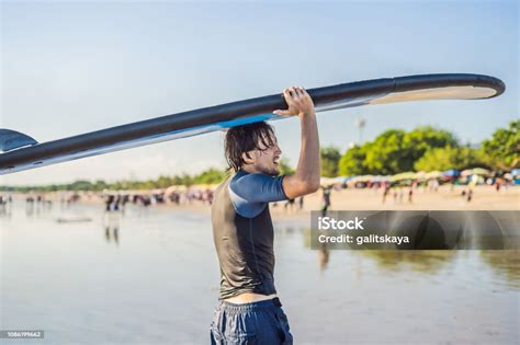 남자는 그의 머리 위로 서핑 보드를 들고입니다 해변에서 머리에 서핑 보드와 잘생긴 남자 닫습니다 Hid 헤드에 서핑 보드를 들고 해변에서 웃 고 남자의 초상화 나름에 대한