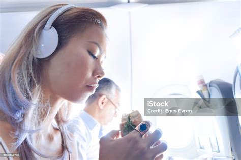 헤드폰으로 음악을 듣고 하 고 비행기로 여행 하는 동안 점심 여자 기내 음식에 대한 스톡 사진 및 기타 이미지 기내 음식 헤드폰 여자 Istock