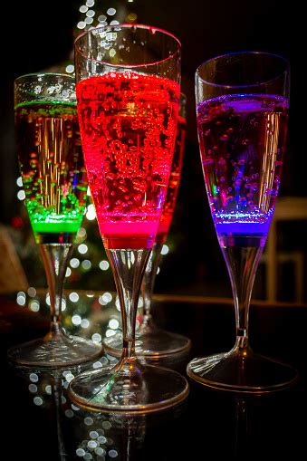 어두운 검은 색 배경에 샴페인 카바 또는 Prosecco로 가득 다채로운 파티 안경 빨간색 파란색과 녹색 거품과 축하를위한 준비 0명에 대한 스톡 사진 및 기타 이미지