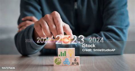 손 스택 우드 블록 아이콘으로 테이블에 단계 실행 계획 목표 및 목표 성공 및 비즈니스 목표 개념 프로젝트 관리 회사 전략 개발 2023 년 긍정적 인 지표 2022년에