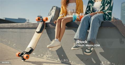다리 스케이트 보드 여성 친구는 야외에서 슬러시 음료를 마시고 휴식을 취하고 여름과 도시에서 즐거운 시간을 보낼 수 있습니다 도시 스케이트 공원에서 우정 데이트와 얼음