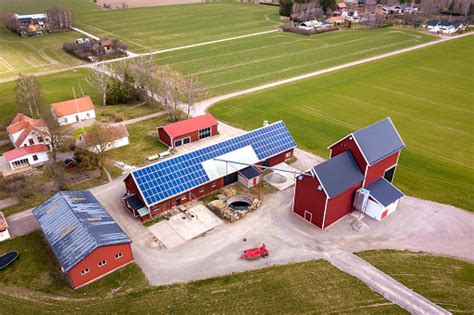 화창한 봄날의 시골 풍경을 감상할 수 있습니다 목조 건물 헛간 또는 집 지붕에 태양 광 화산 패널 시스템을 갖춘 농장 녹색 필드 복사 공간 배경입니다 재생 가능 에너지 생산