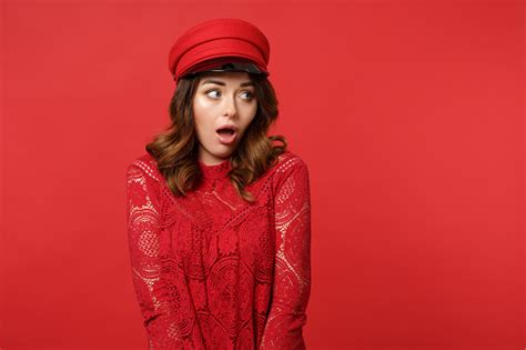 레이스 드레스에 충격 젊은 여자의 초상화와 모자를 입을 열어 스튜디오에서 밝은 빨간색 벽 배경에 고립 된 찾고 사람들은 진심으로 감정 라이프 스타일 개념입니다 복사 공간을