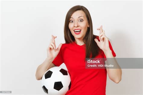 유럽 젊은 여자 축구 팬 이나 선수 빨간색 유니폼 계속 손가락을 엇갈리게 잡고 축구공 흰색 배경에 고립 스포츠 축구 라이프 스타일 개념을 재생 합니다 특별 한 순간을