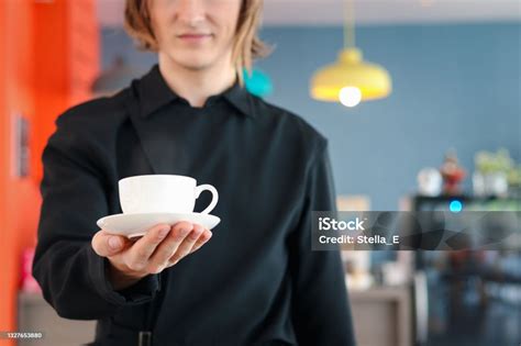 카페 숍에서 뜨거운 커피 한 잔을 들고 바리스타 손을 닫고 커피 숍 카운터 바에서 고객에게 커피를 제공하는 웨이터 직원 카메라에